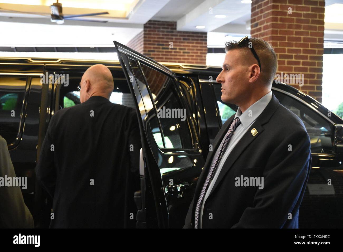 An Army CID special agent on protective detail prepares for a motorcade ...