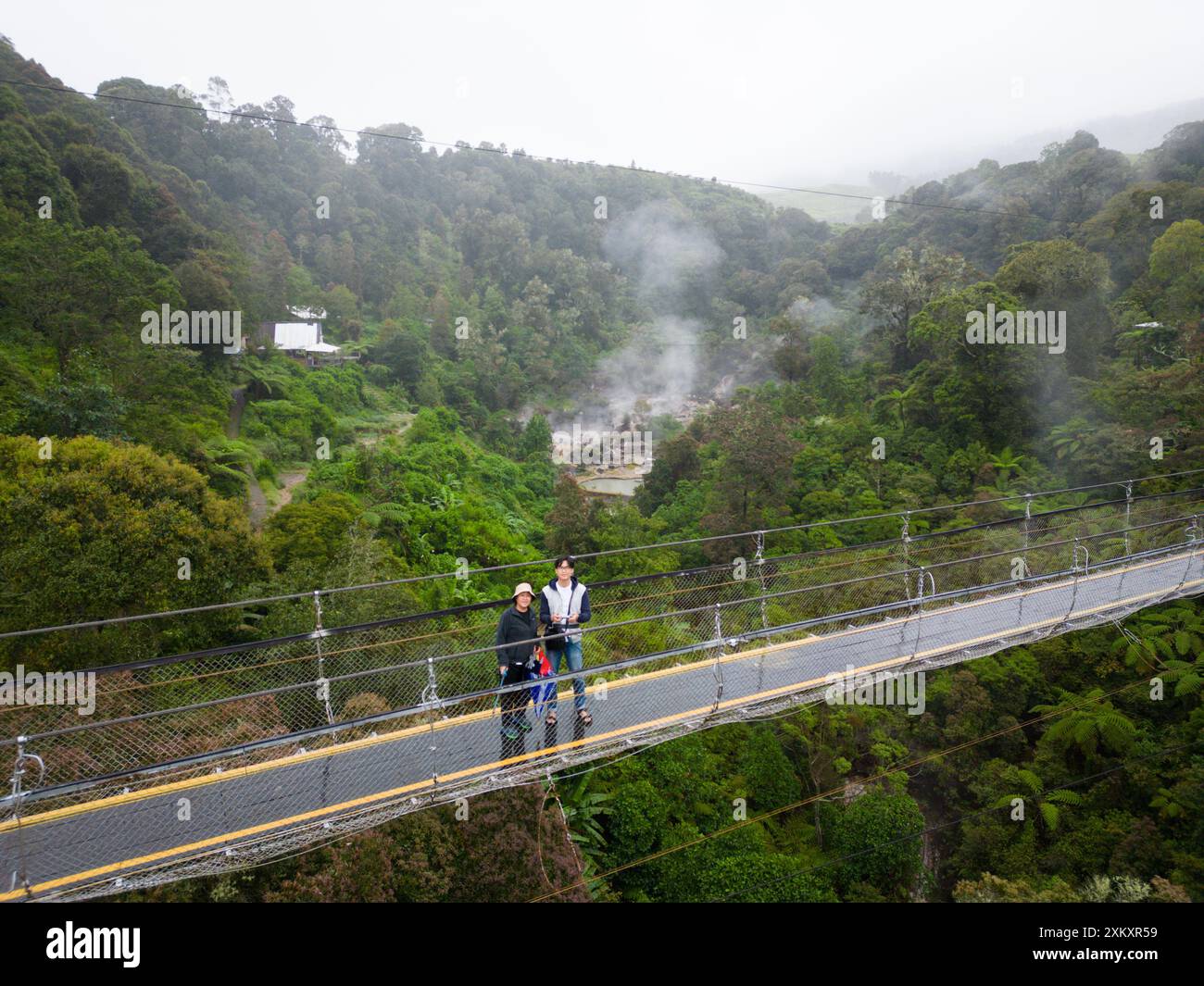 Tourists on Rope Suspension Bridge with Forest and Misty Valley Aerial ...