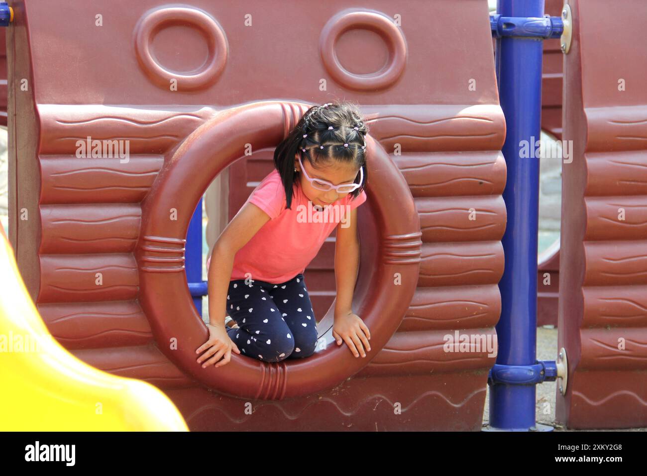 5 year old Latin brunette girl plays in the park playground away from ...