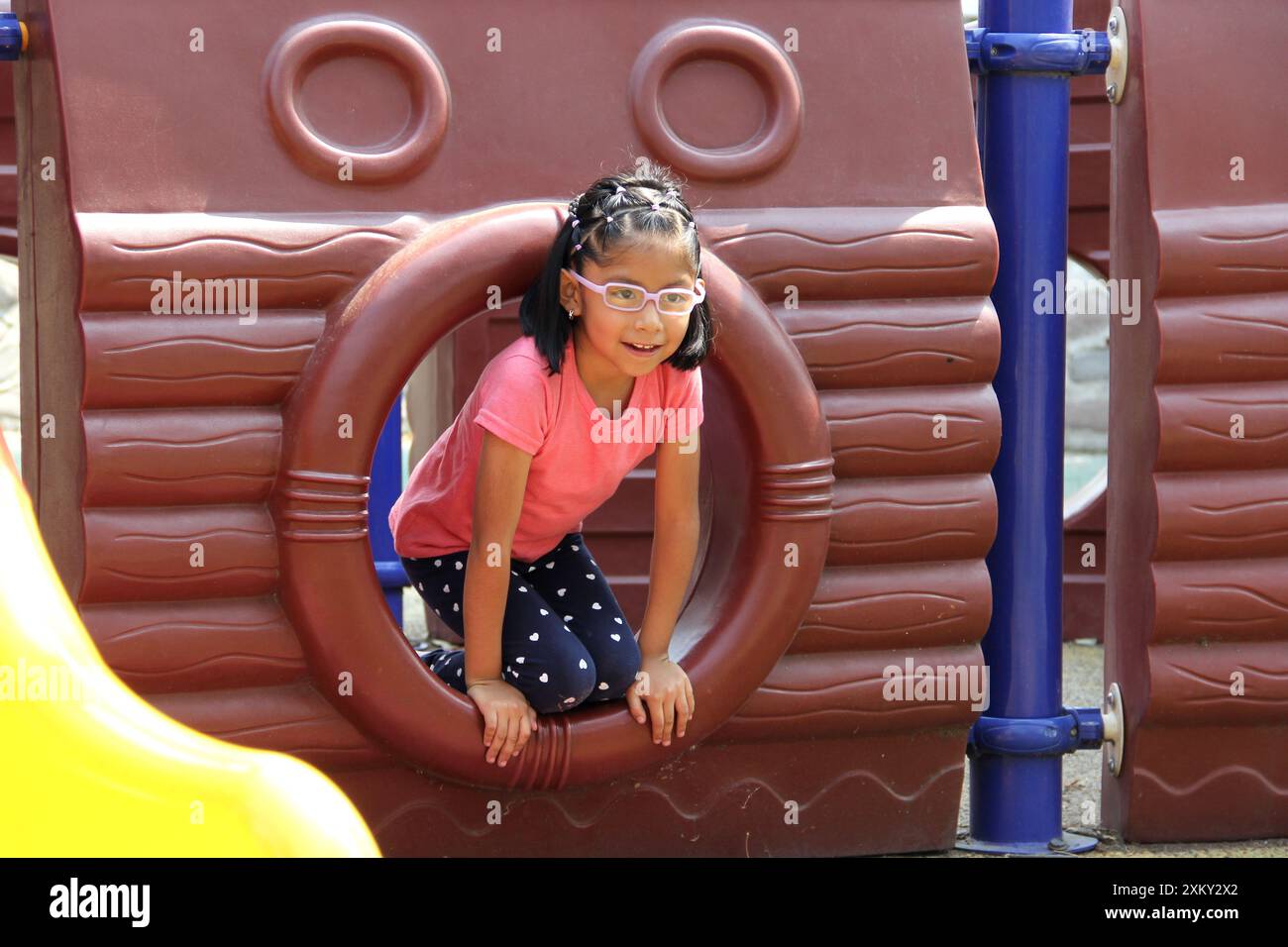 5 year old Latin brunette girl plays in the park playground away from ...