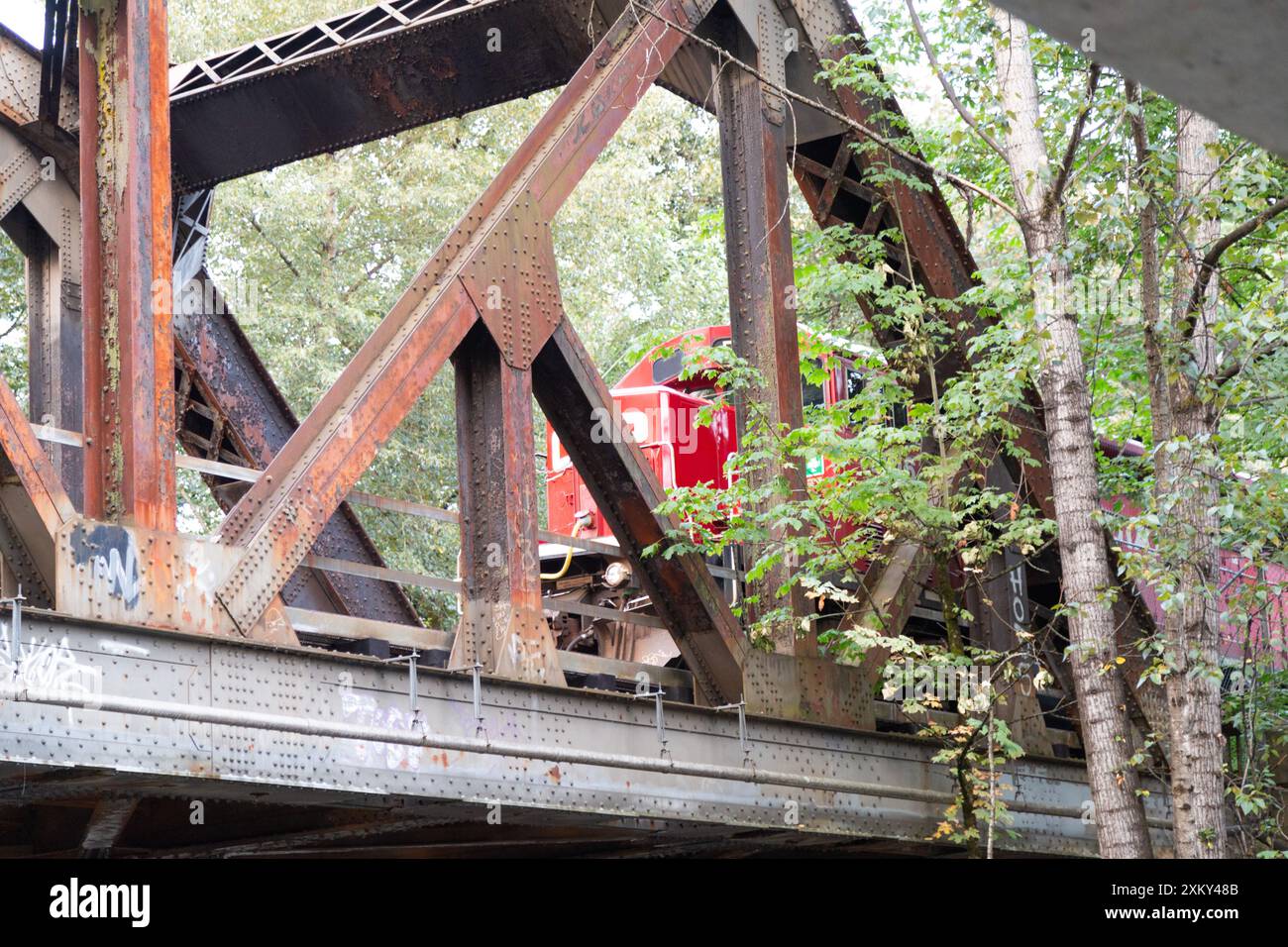 Red train crossing a bridge in Port Coquitlam, Canada Stock Photo - Alamy