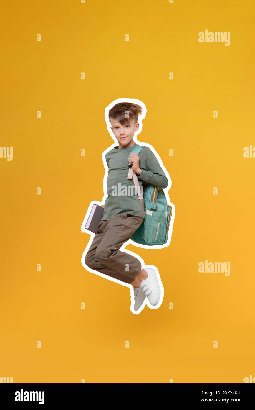 Cute school child with book jumping on orange background Stock Photo ...