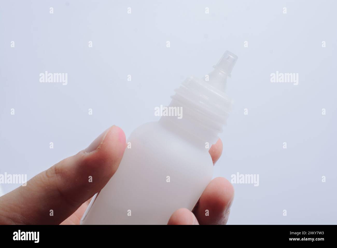 White empty dropper bottle in hand on a white background Stock Photo ...