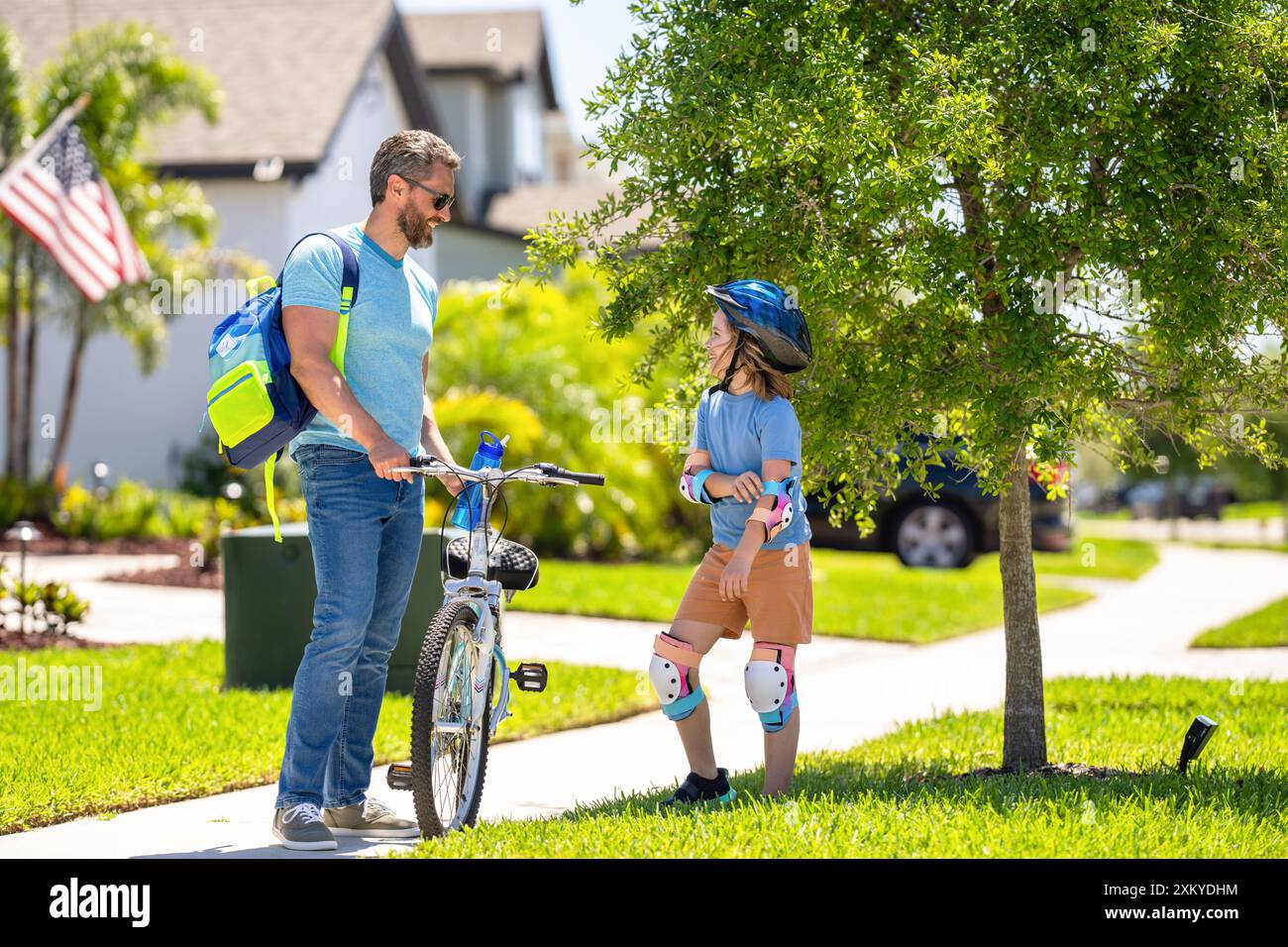 dad guiding his son first bike ride. dad and son enjoying fun bike ...