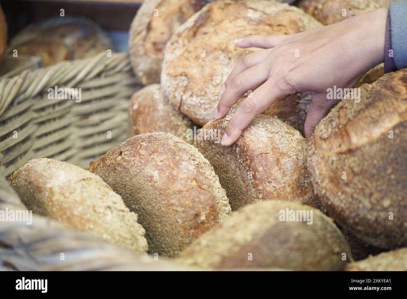Selecting fresh bread from an artisan bakery basket is a delightful ...