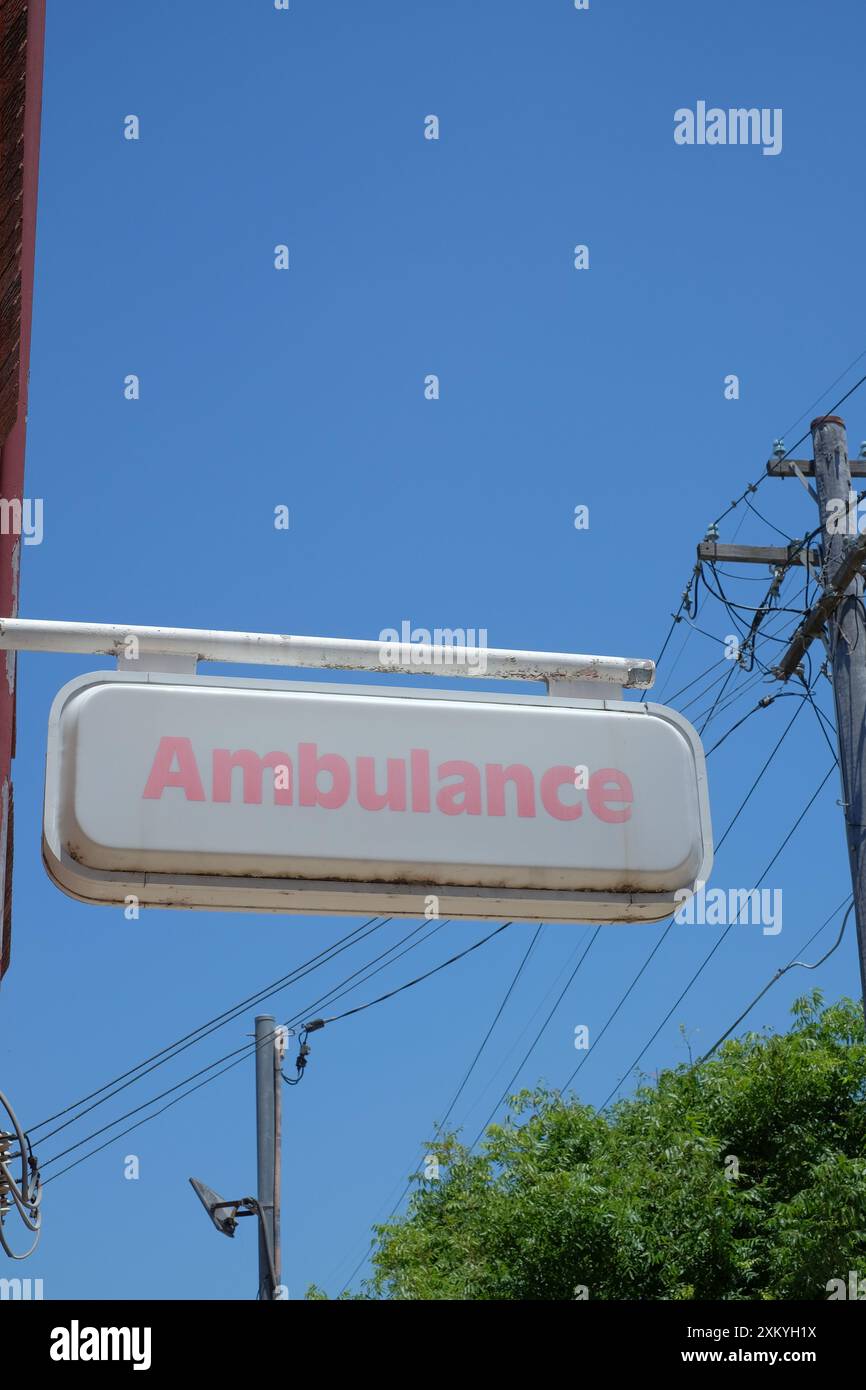 NSW Ambulance sign seen against blue sky on a wall outside a depot ...
