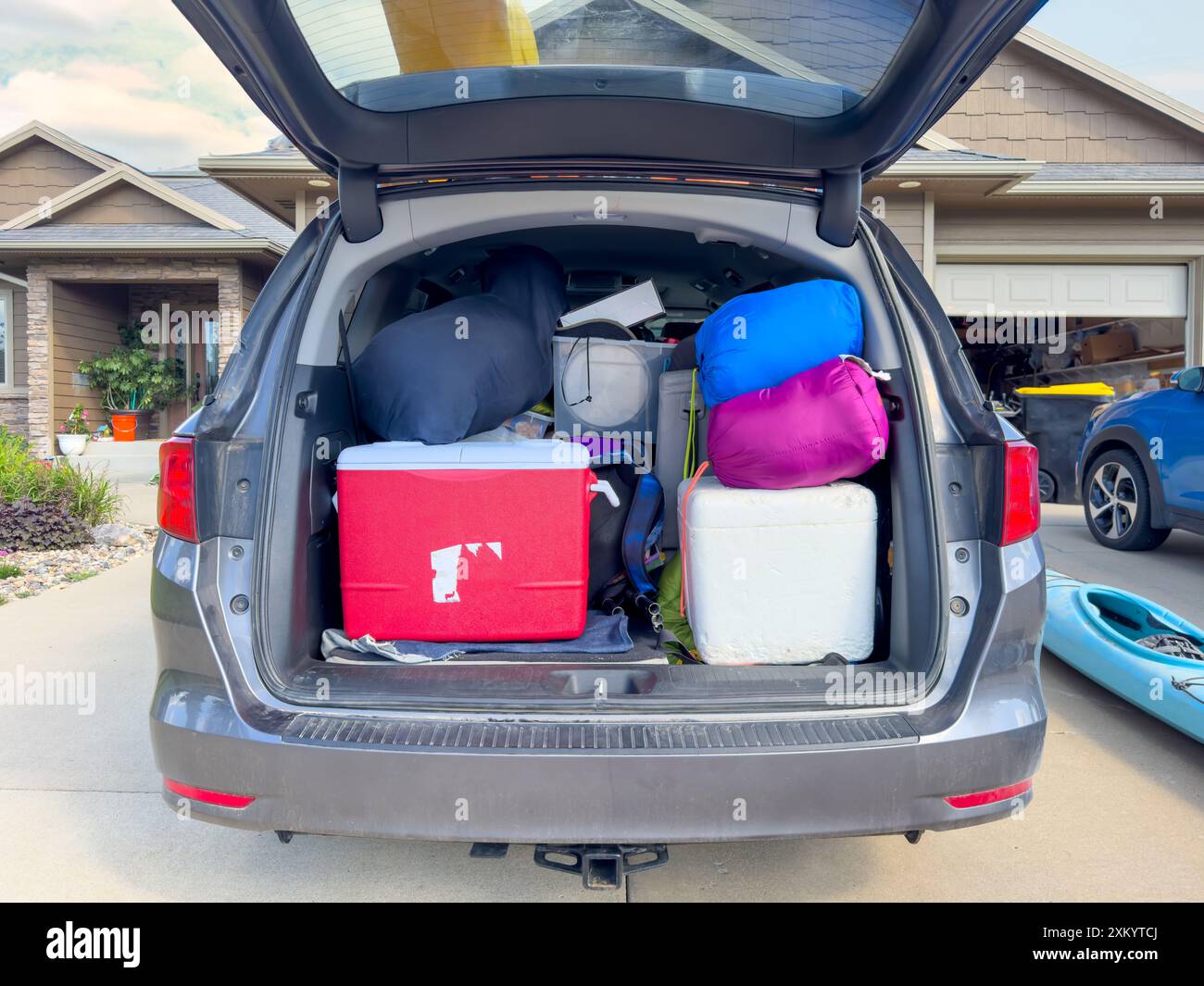 Full van packed for a camping trip with the back open Stock Photo - Alamy