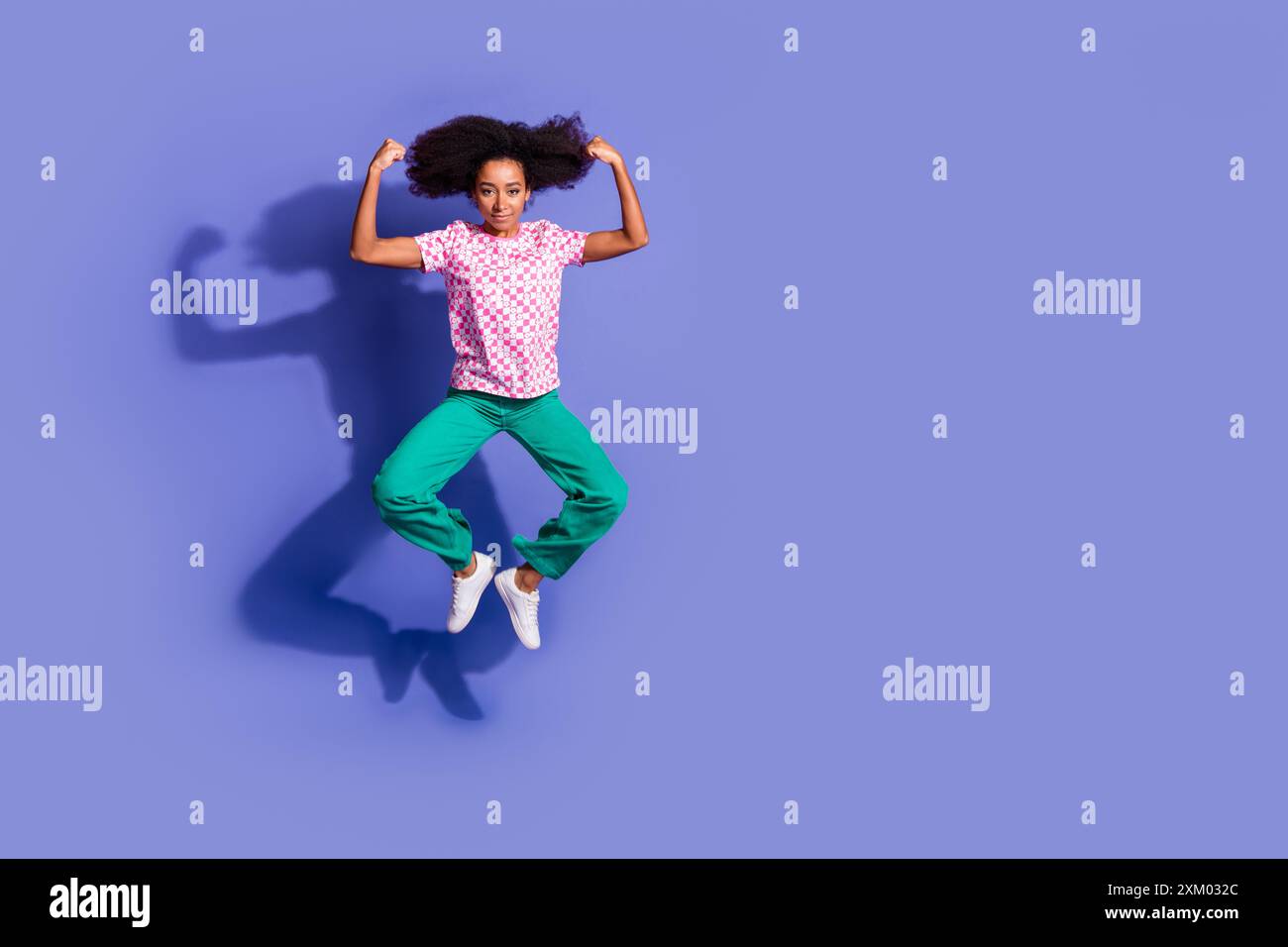 Full length photo of lovely young lady jump flexing muscles dressed ...