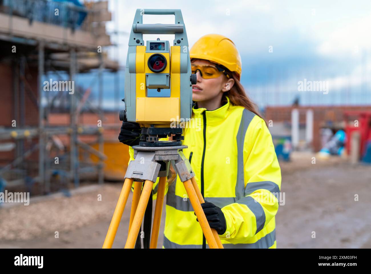 Female site engineer surveyor working with theodolite total station EDM ...