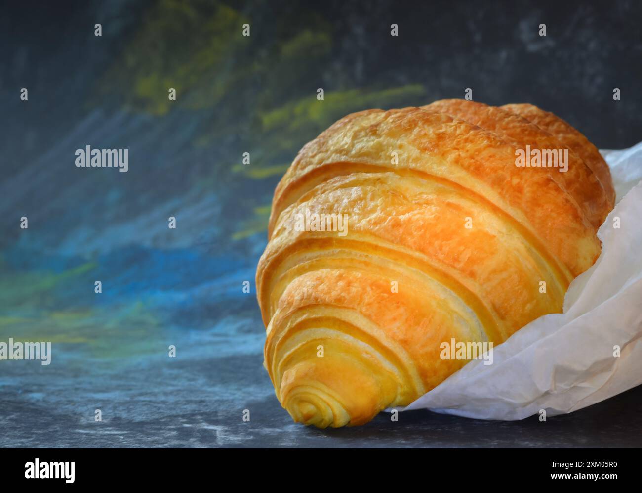 Dark background with croissant in white paper in horizontal format ...