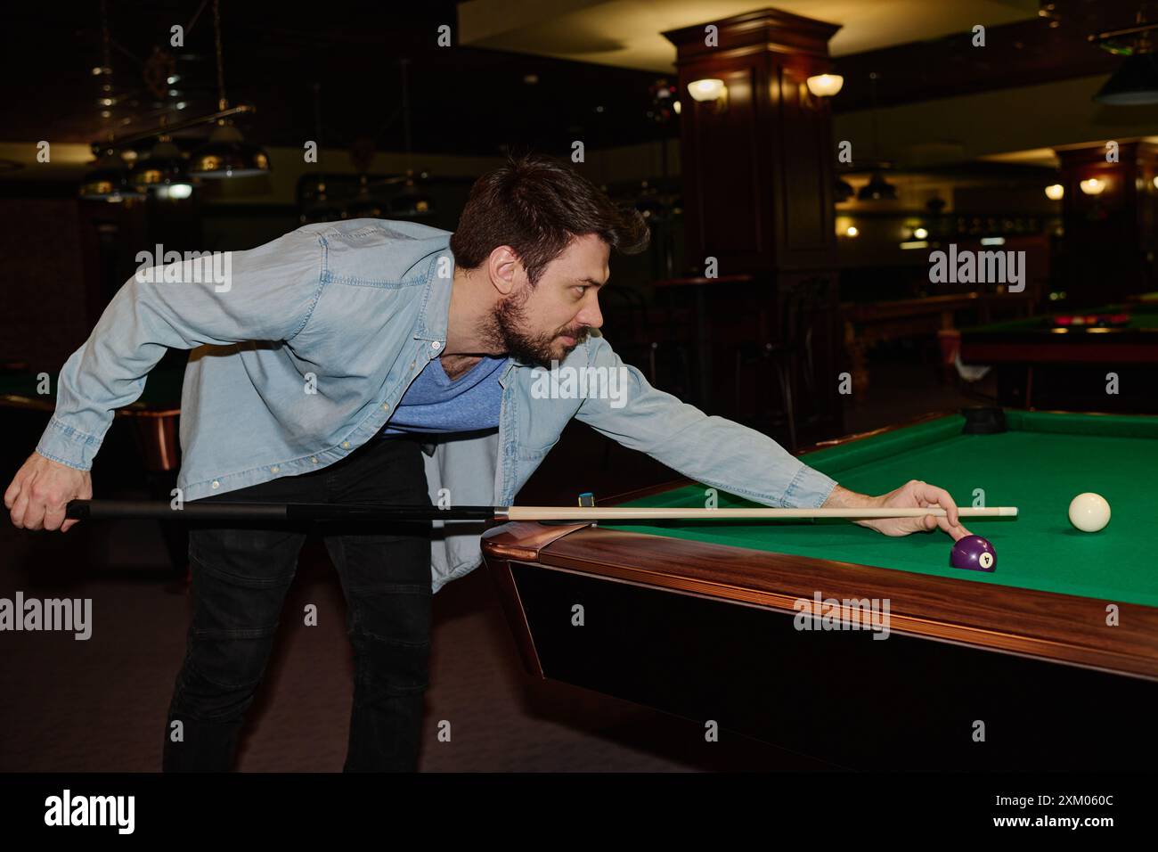Side view of young man in black jeans and denim shirt standing by wide ...