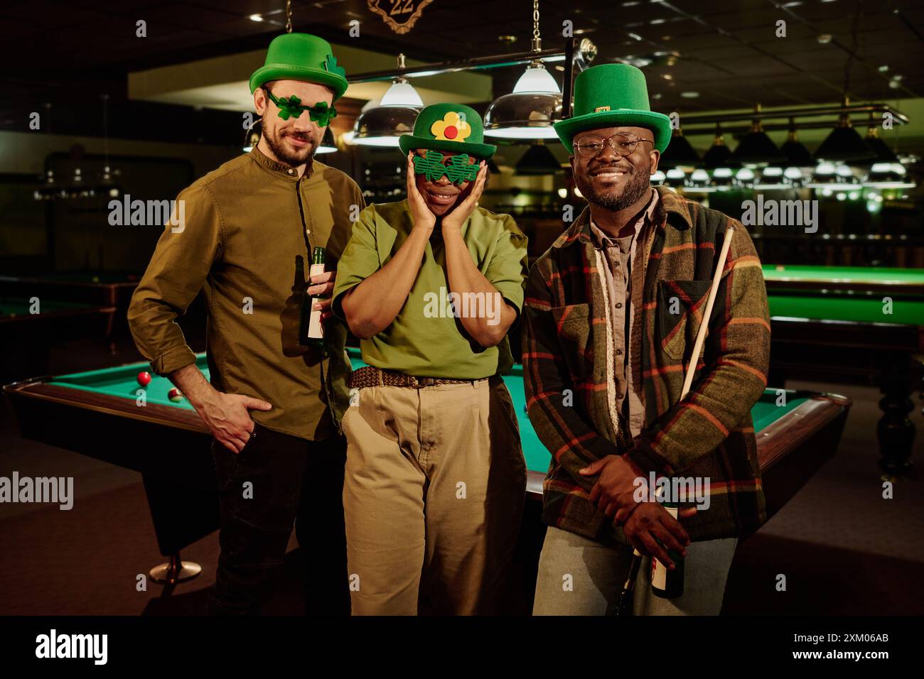 Group of young intercultural friends in green hats and shamrock ...