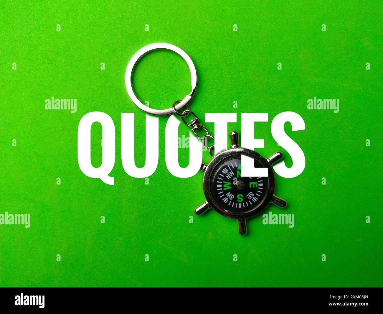 Top view compass keychain with word QUOTES on a green background Stock ...