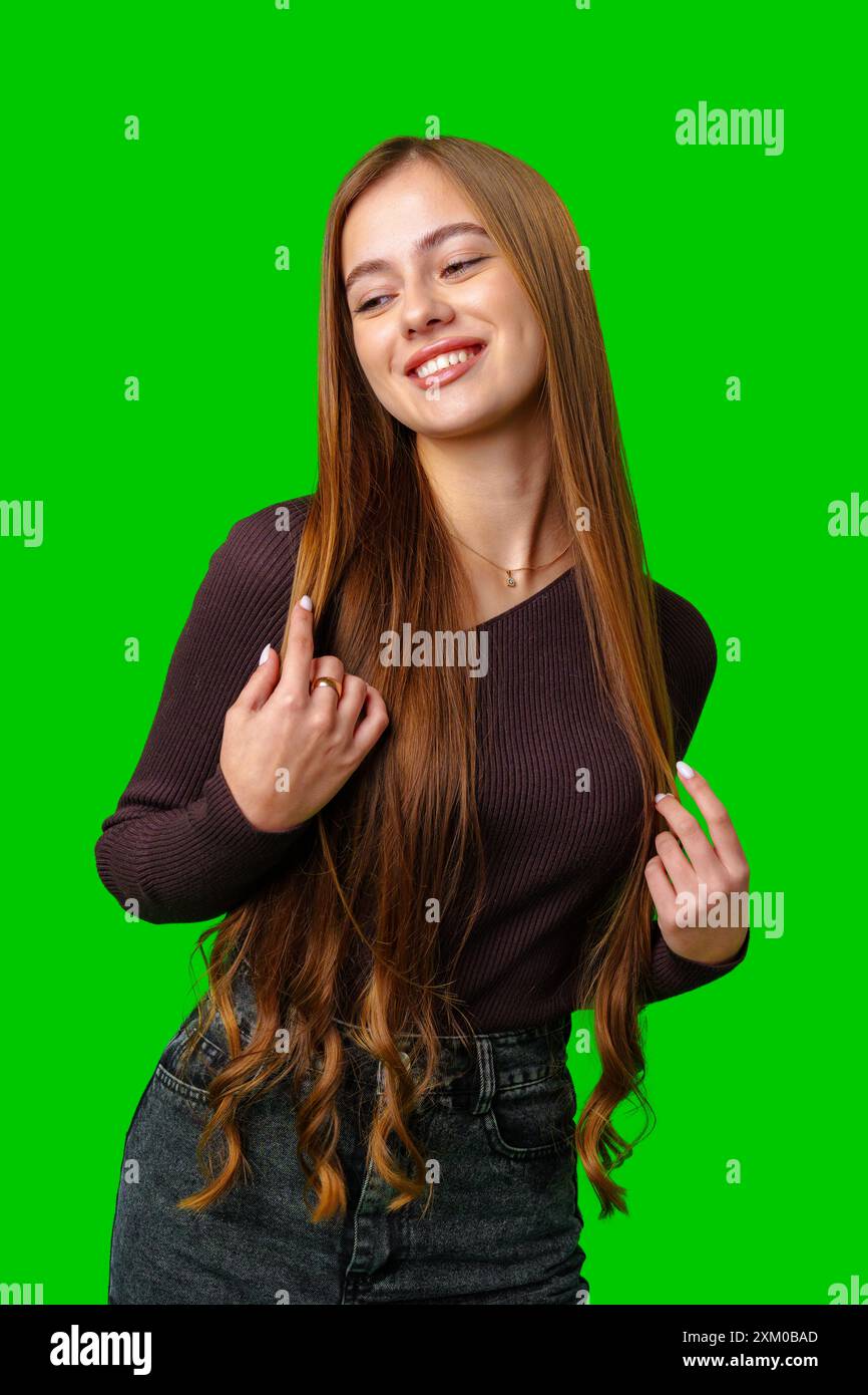 Smiling Woman With Long Brown Hair Adjusting Her Clothes in Front of a ...