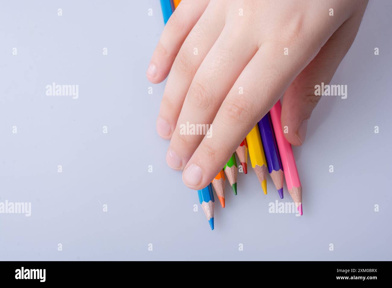 Hand holding color Pencils placed on a white background Stock Photo - Alamy