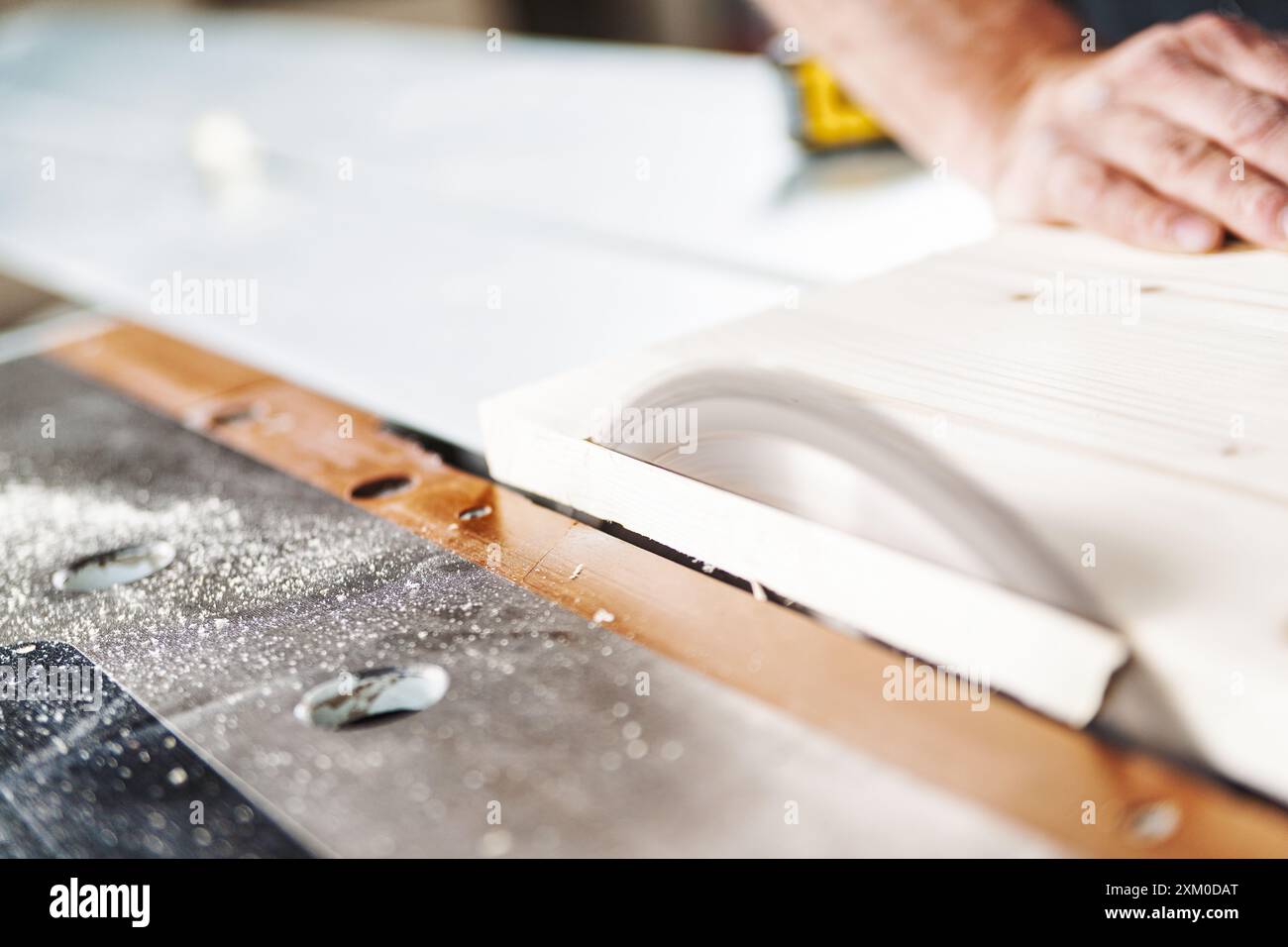 Carpenter is using a circular saw to cut a wood plank in a carpentry ...