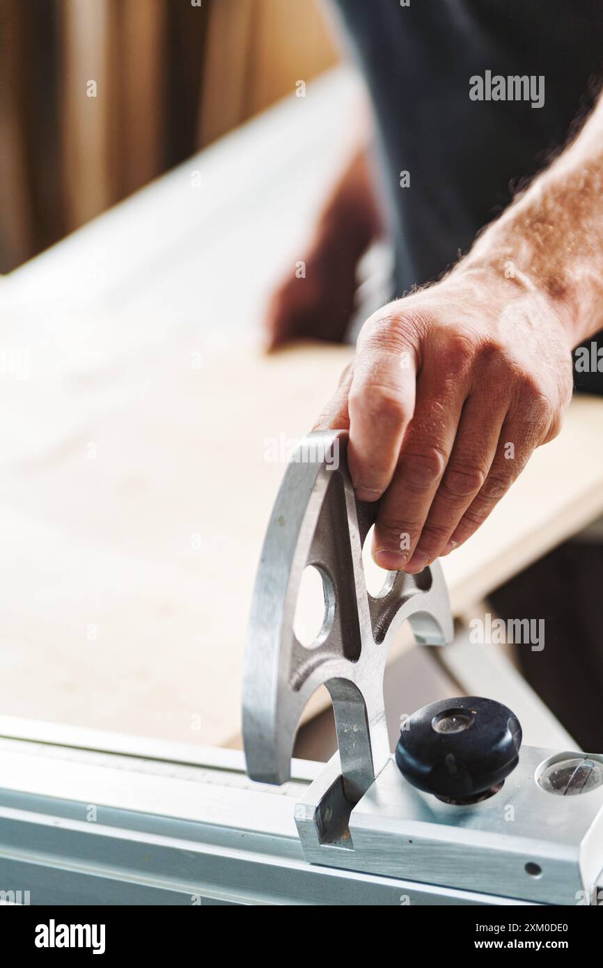 Carpenter is using a circular saw guide rail for cutting a wood plank ...
