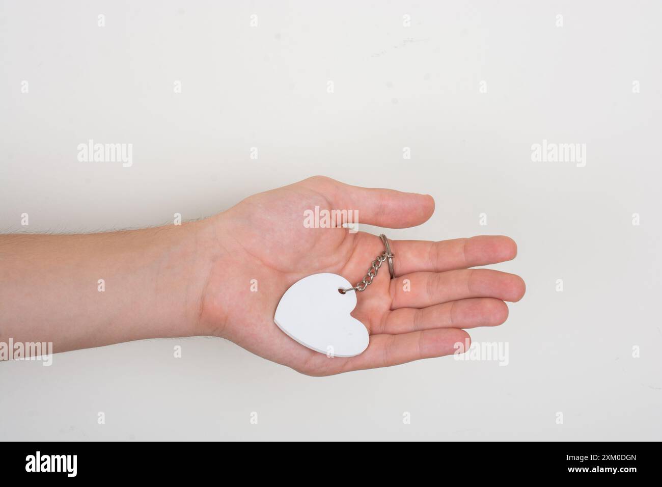Heart shaped white object in hand on white background Stock Photo - Alamy