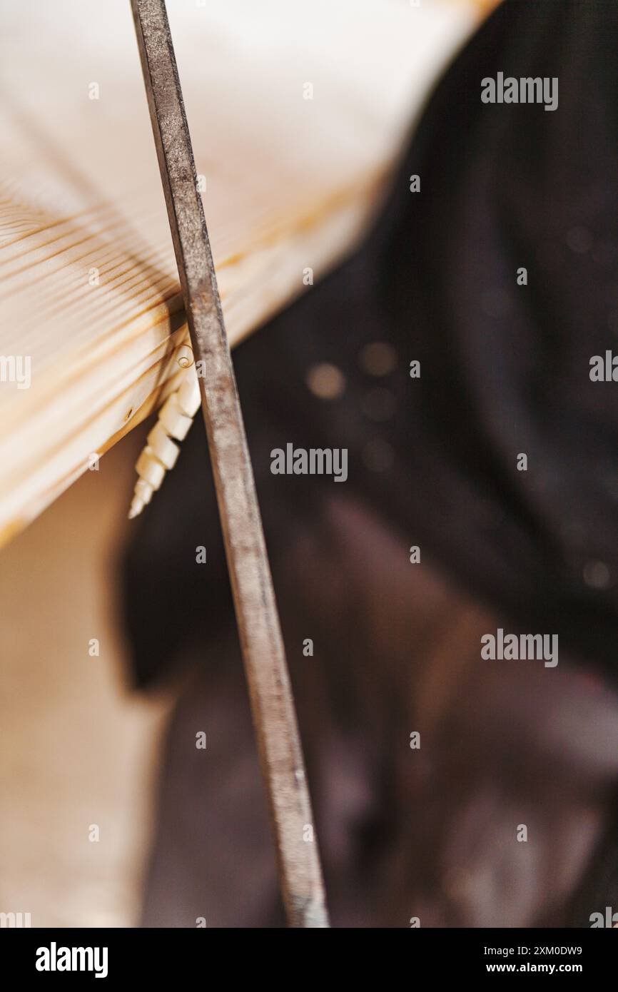 Carpenter shaping wood with a chisel in a cozy workshop, focusing on ...
