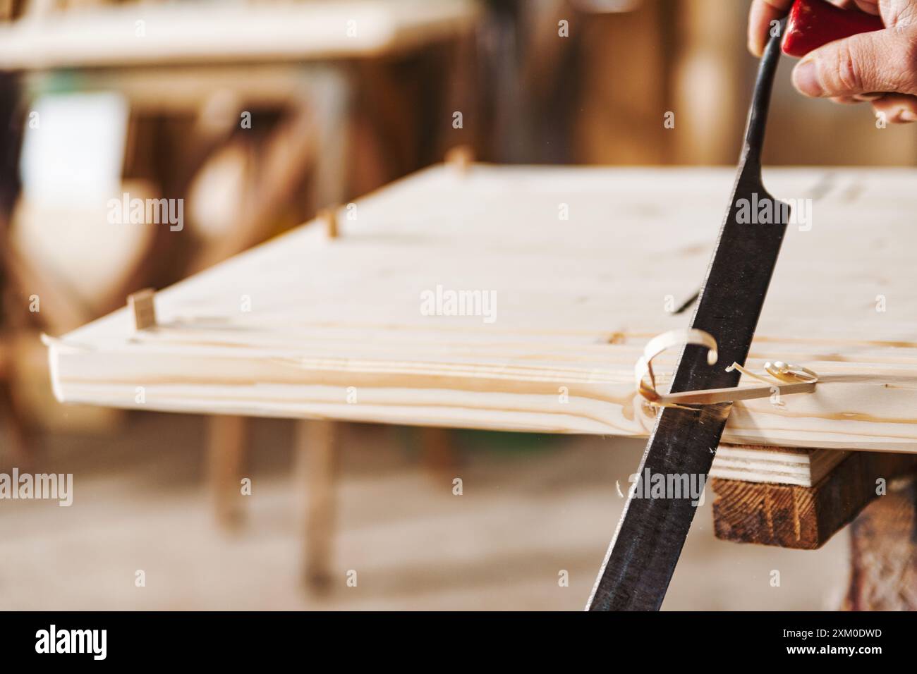 Skilled carpenter shaping wood plank with hand plane in cozy workshop ...