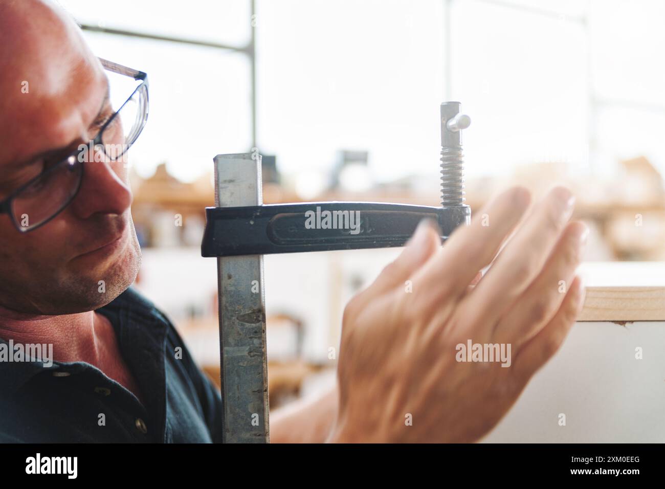 Focused carpenter expertly joins wood pieces in a workshop, showcasing ...