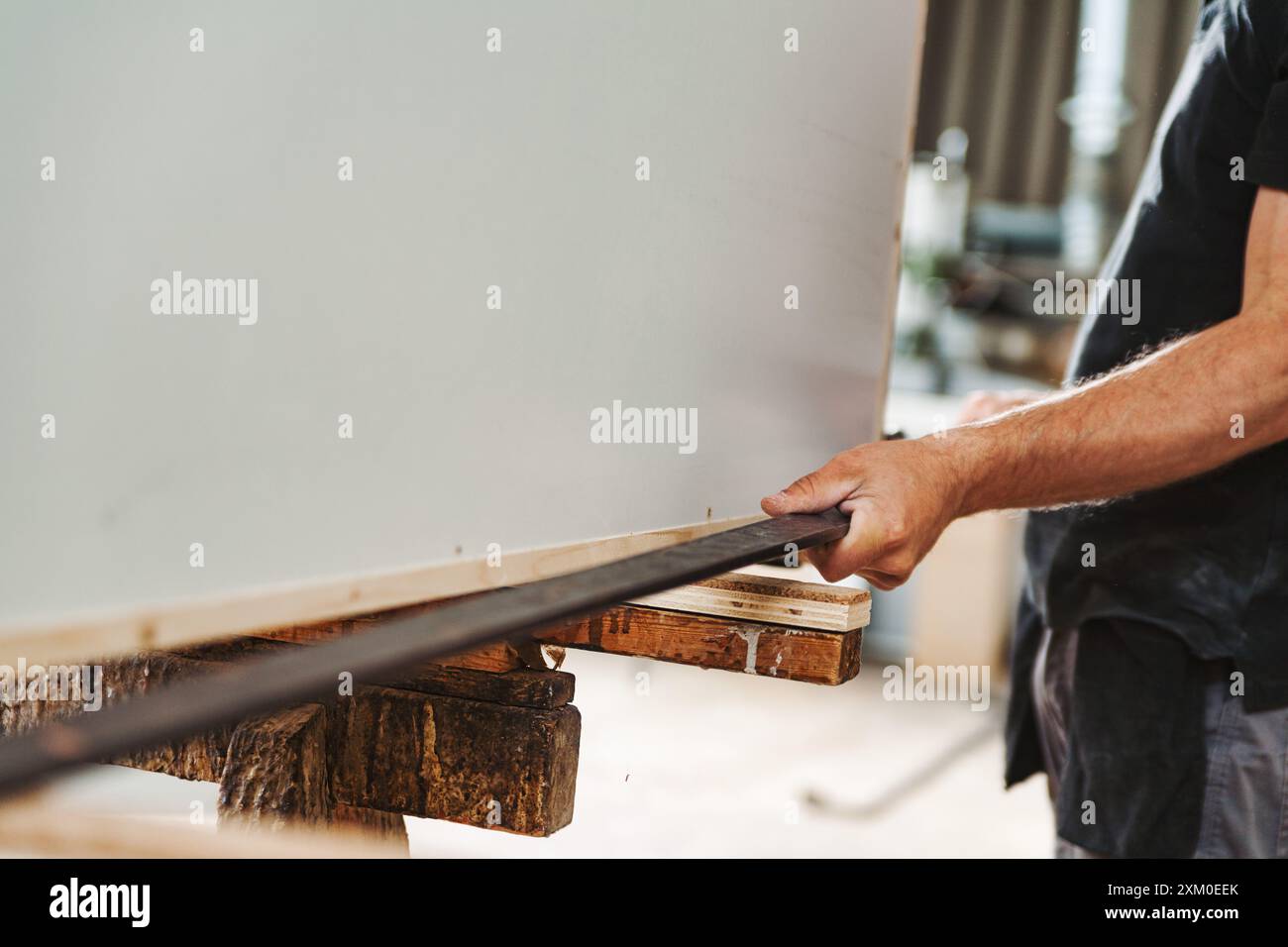 Carpenter is using a crowbar to repair a large wooden panel in his ...