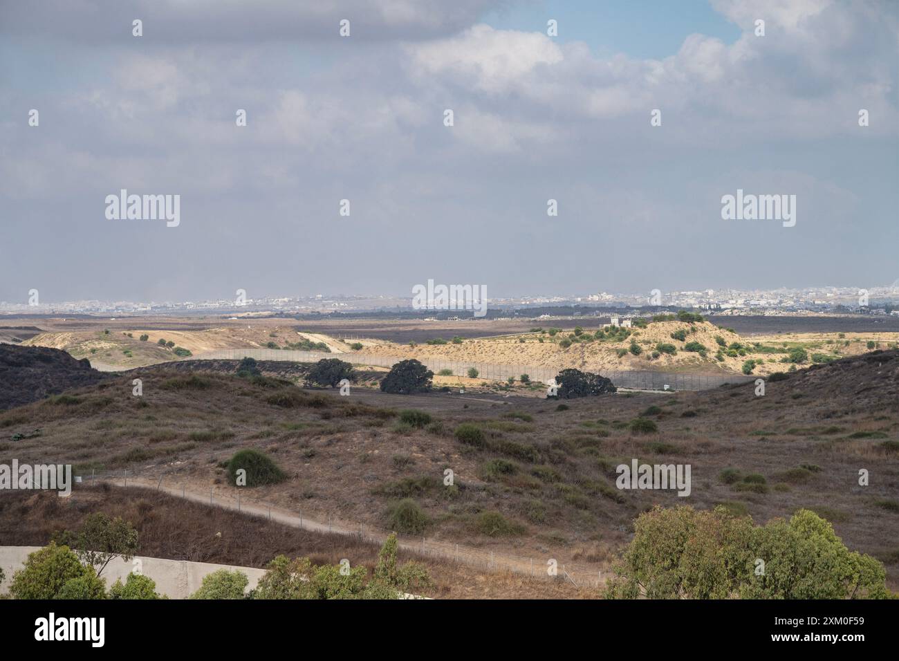 the sun lights up a section of the Gaza Strip behind the border fence ...