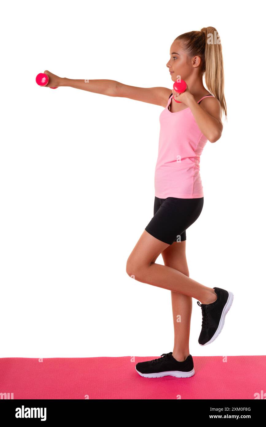 Healthy fitness teen girl in full length doing exercises with dumbbells ...