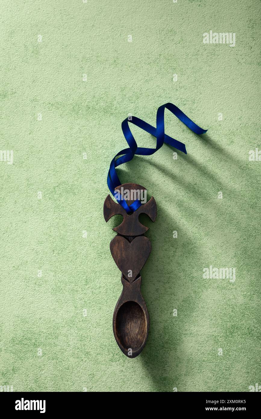 Carved wooden love spoon with blue ribbon Stock Photo - Alamy