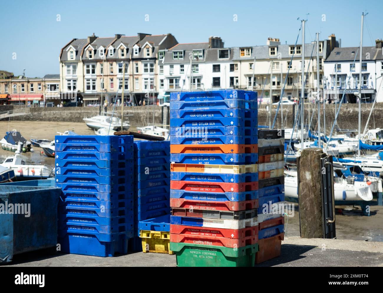 Empty plastic fish crates left on the quayside Stock Photo - Alamy