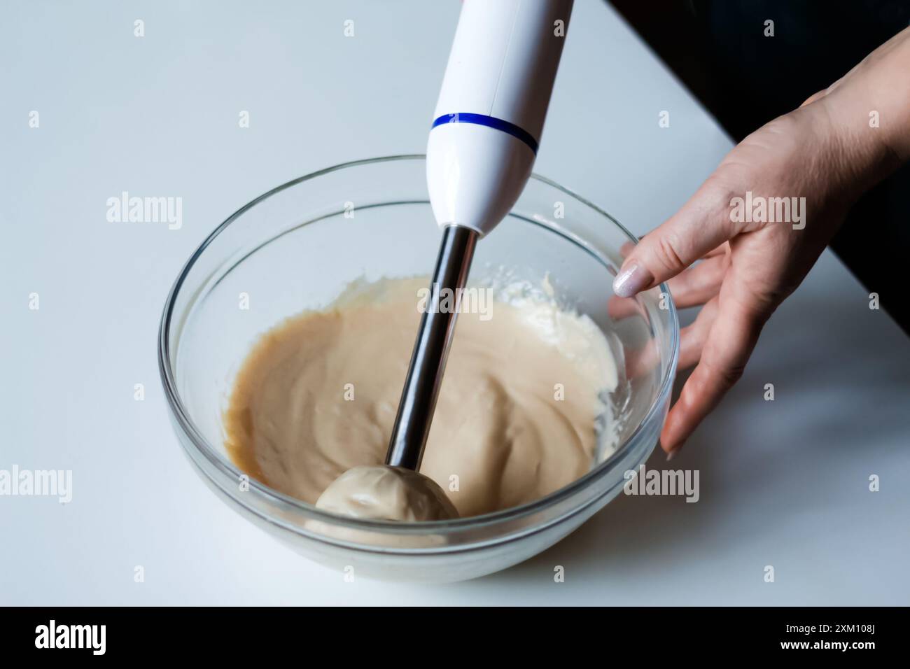 A chef's skilled hands blending homemade mayonnaise with olive oil ...