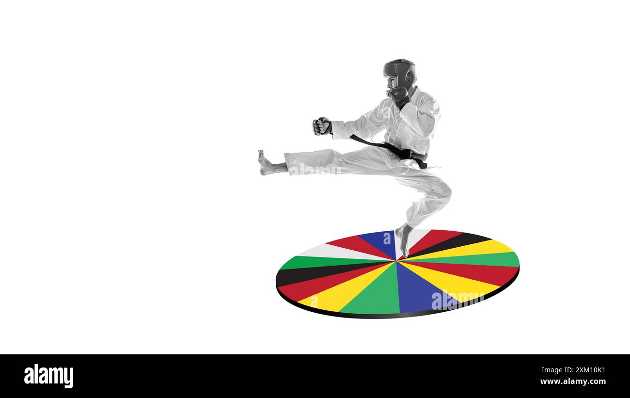 Martial artist in monochrome performing high kick over vivid circle of ...