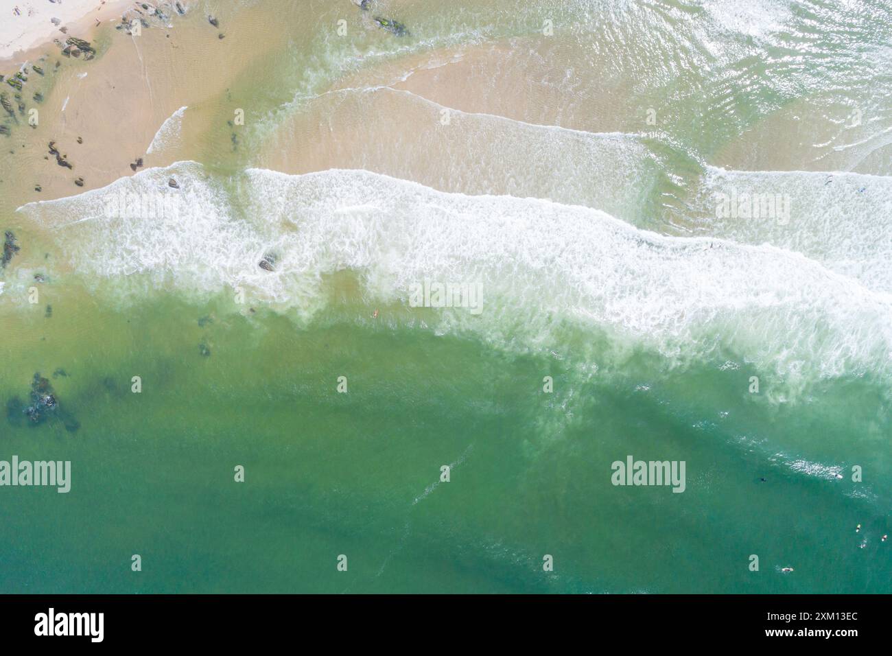 waves on the shore of a beach in the summer, aerial overhead view with ...