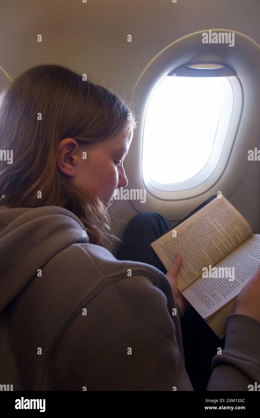 Fourteen 14 year old girl child girl kid reading her novel type book on ...