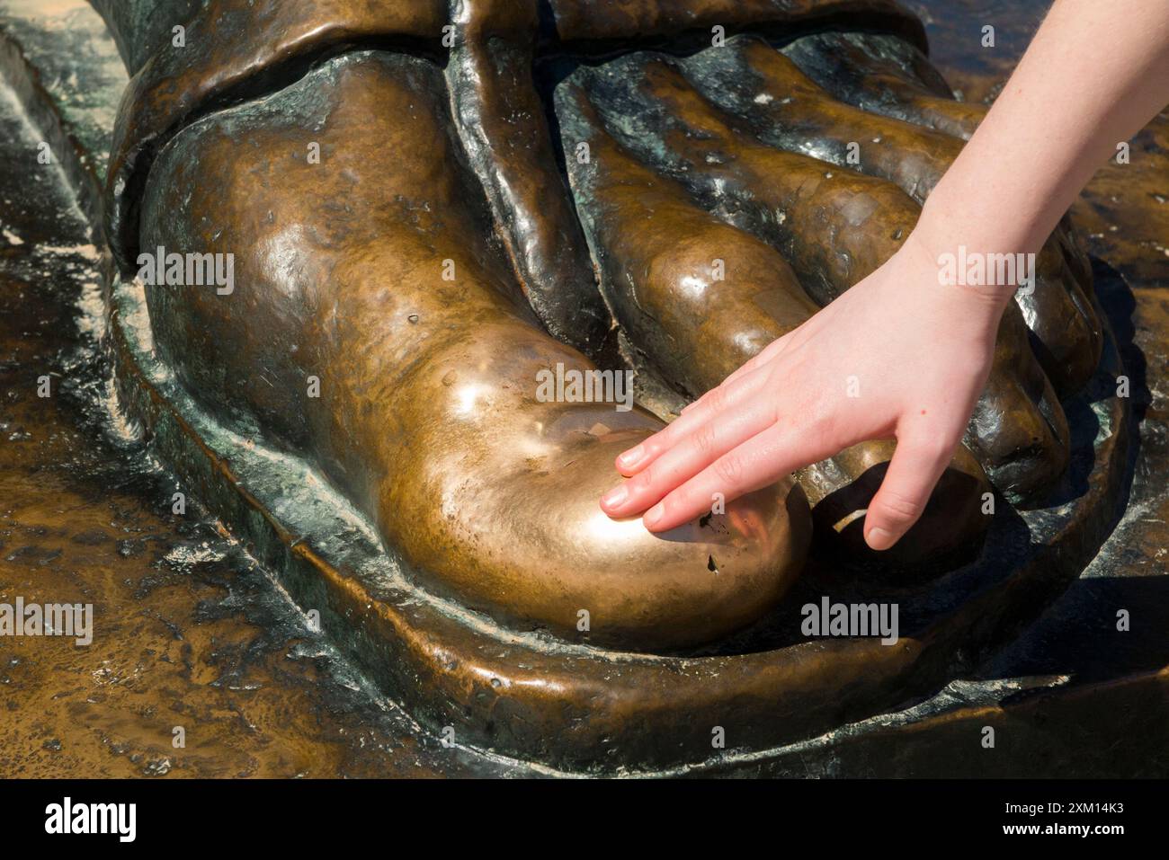 Tourist hand touching big toe on foot, for luck; statue of Croatian ...