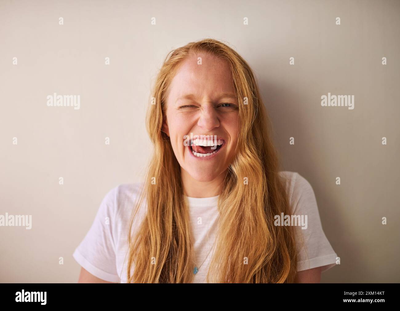 Woman, portrait and tongue on wall background with smile, excited and ...