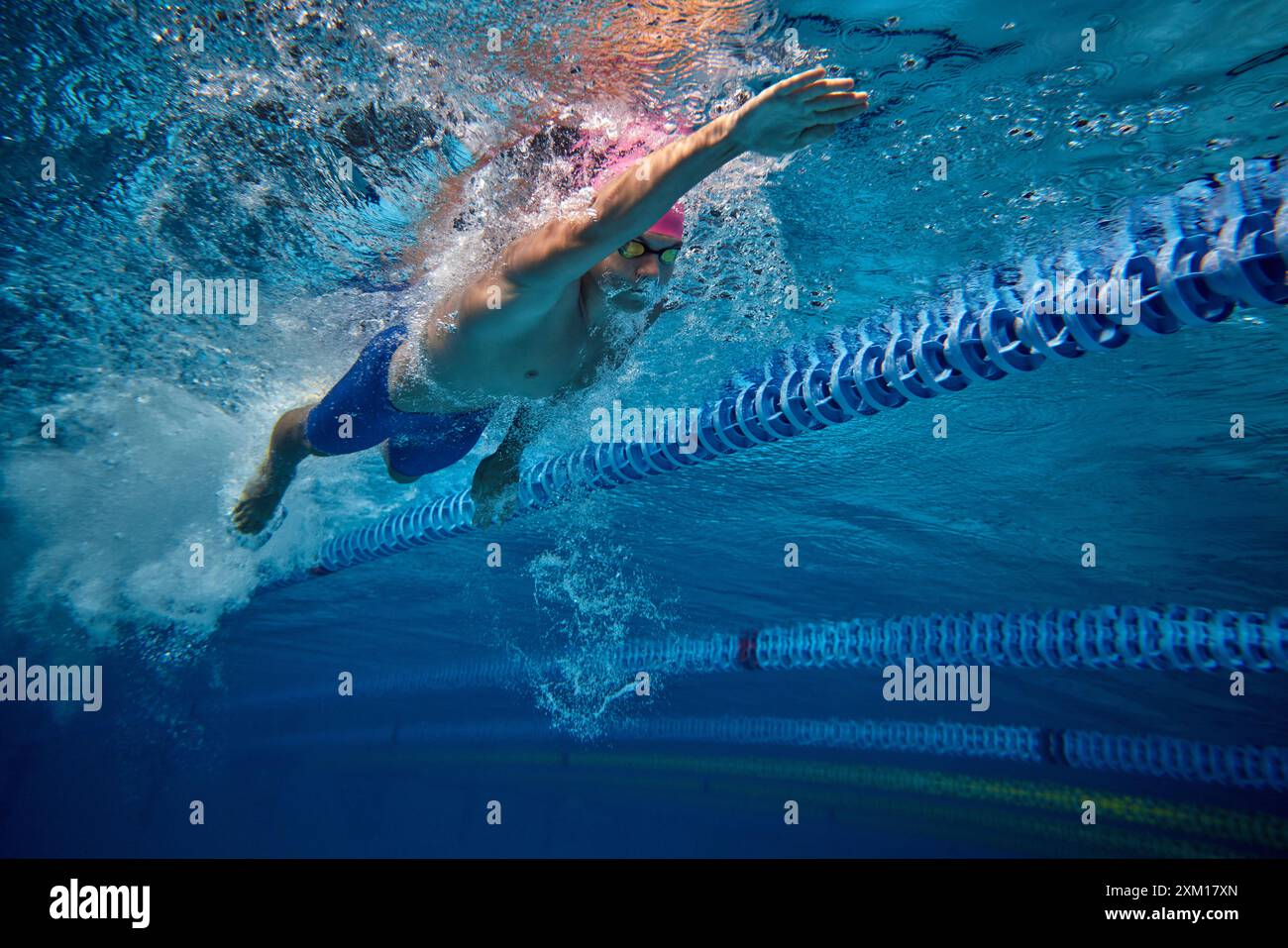 Male athlete swimming, highlighting his focus and form, as he pushes ...