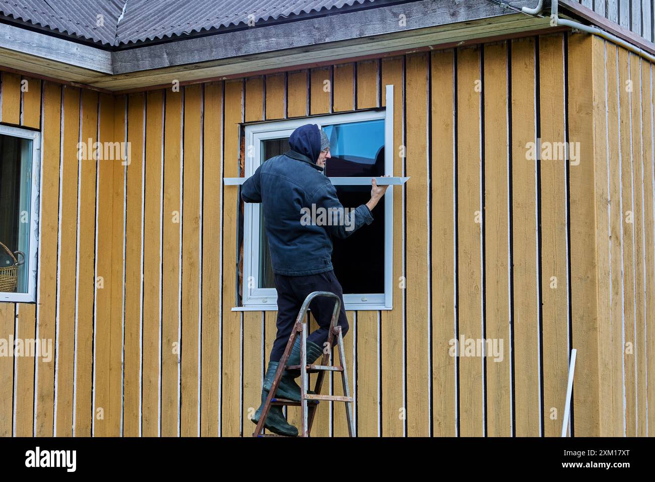 Exterior finishing of facade of frame house, builder installs metal ...
