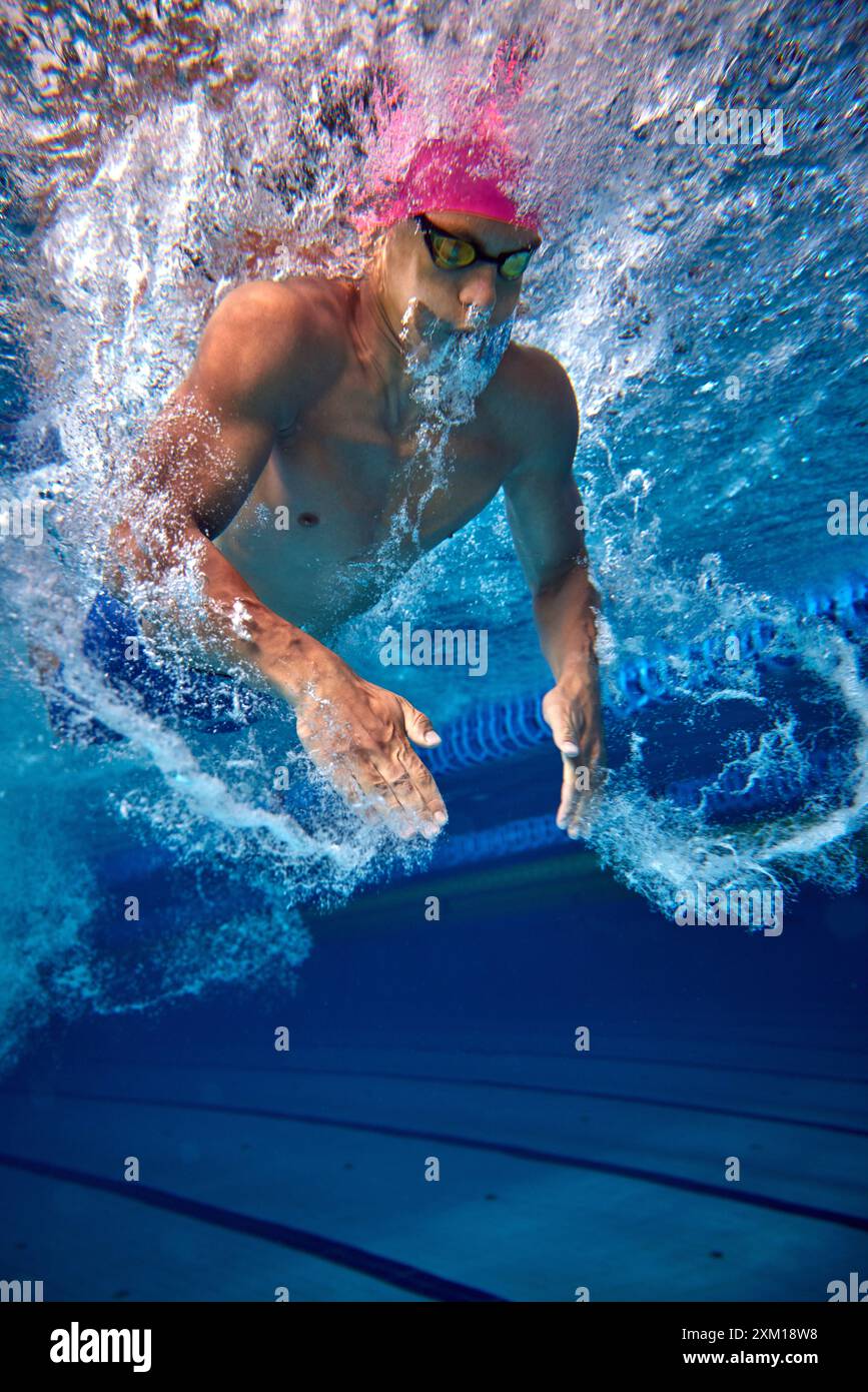 Underwater shot of dedicated swimmer in training, wearing pink cap and ...