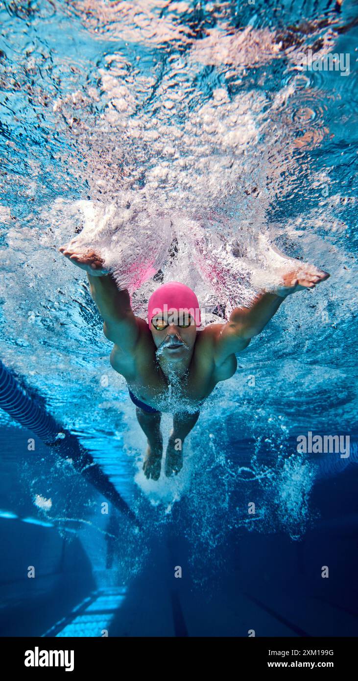 Underwater view of young man, swimmer wearing goggles in competitive ...