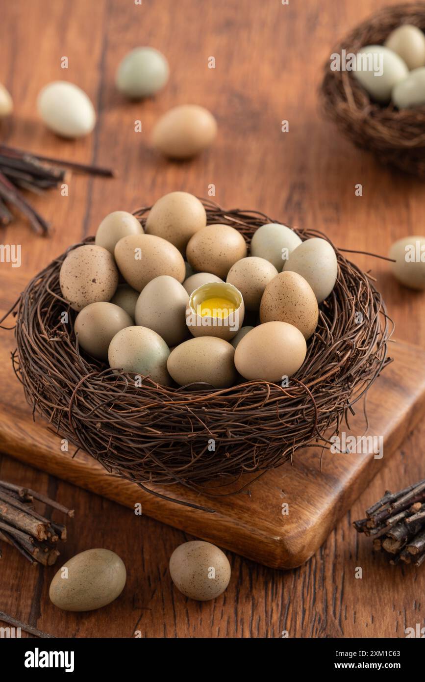 Fresh button quail eggs in a nest on wooden table background Stock Photo - Alamy
