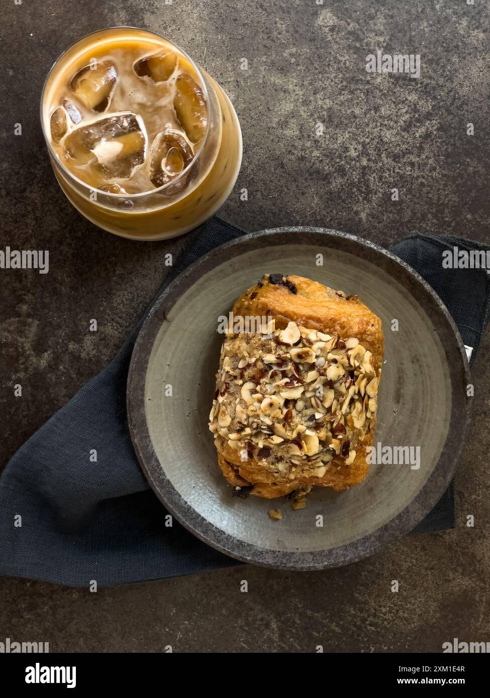 Iced coffee and freshly baked pastry on rustic ceramic. Dark background ...