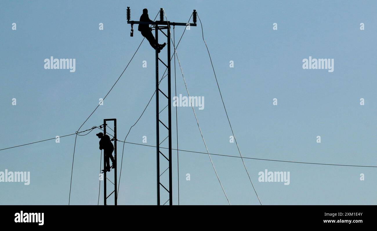 Electricians working on ladders to lay electrical wires Stock Photo - Alamy