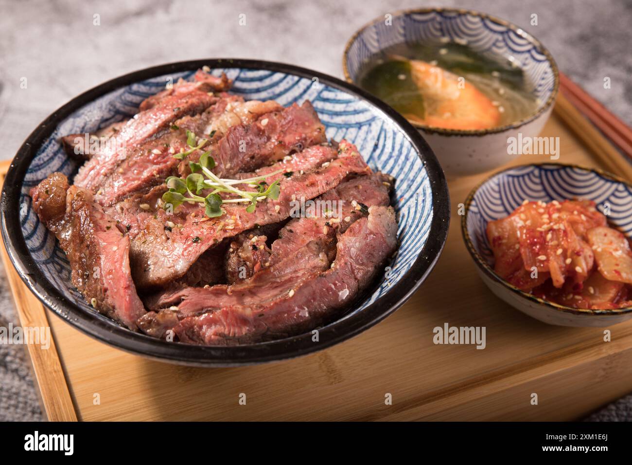 The closeup Yakiniku Don, grilled beef meats (yakiniku) topped on a bowl of rice (donburi) with ...