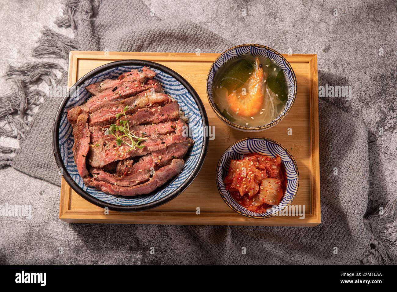 The closeup Yakiniku Don, grilled beef meats (yakiniku) topped on a bowl of rice (donburi) with ...