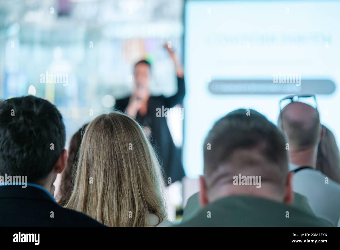 Audience attentively listening to a business presentation by a speaker ...