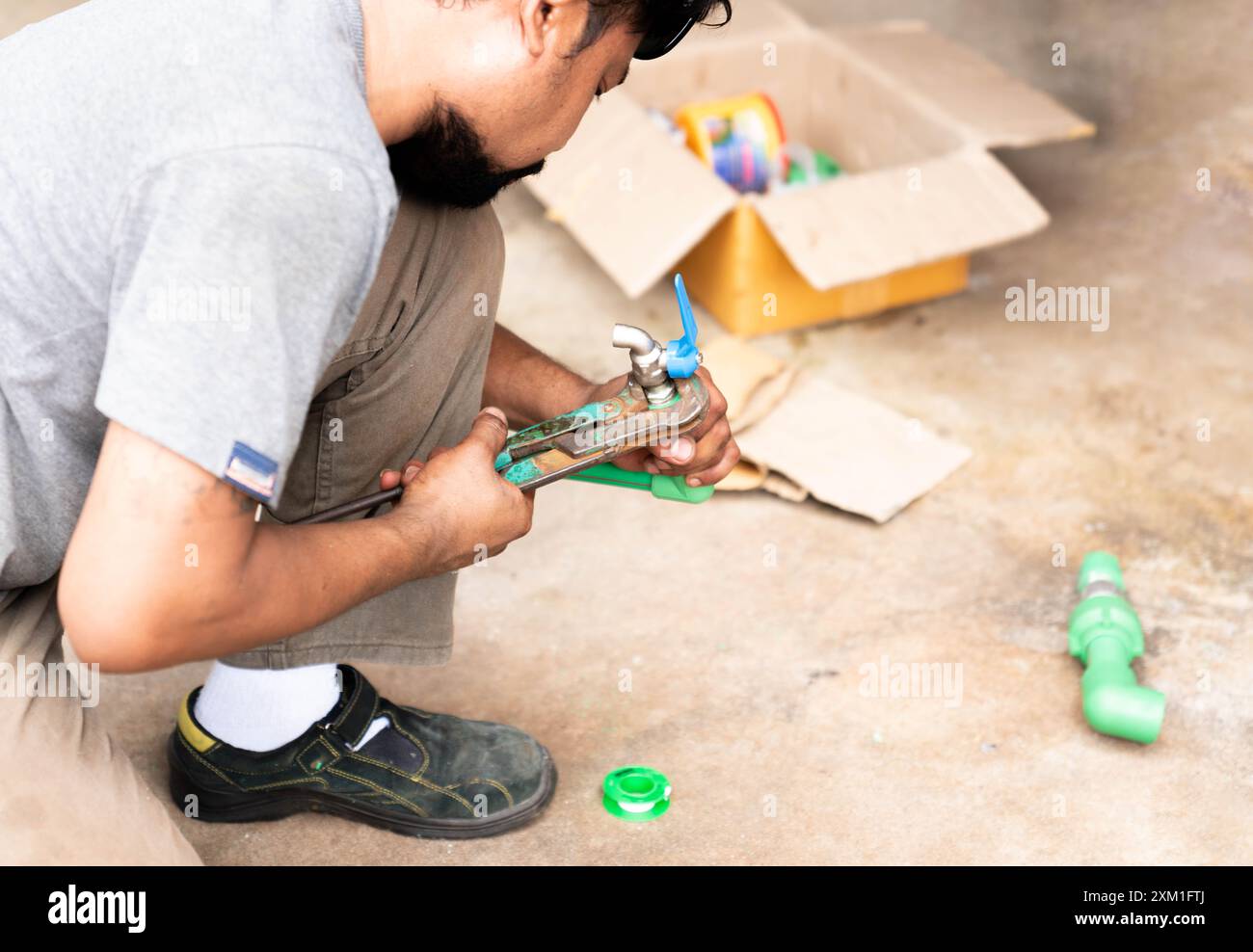 Plumber installing new tap in factory water supply system. Repair tap ...