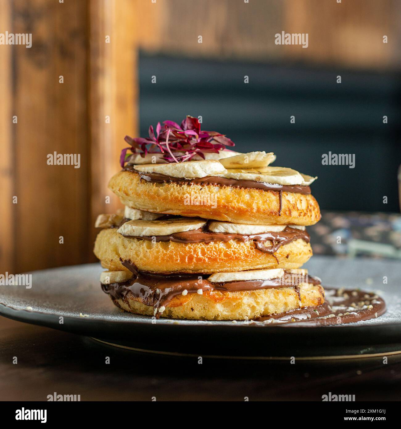 Homemade fluffy banana pancake with chocolate on a coffee shop table ...
