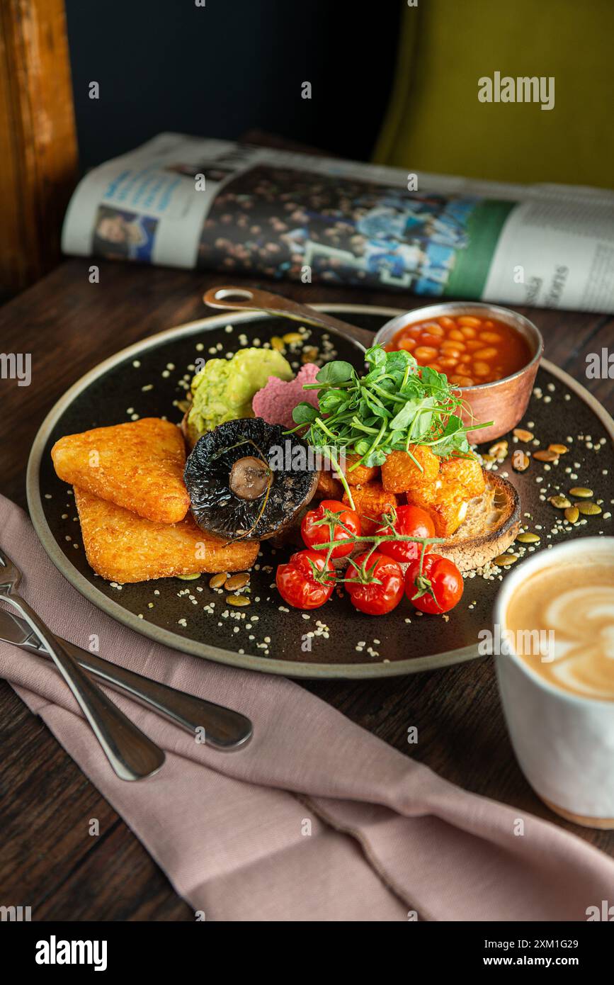 English Breakfast on a black ceramic plate. Wooden table. Full English ...