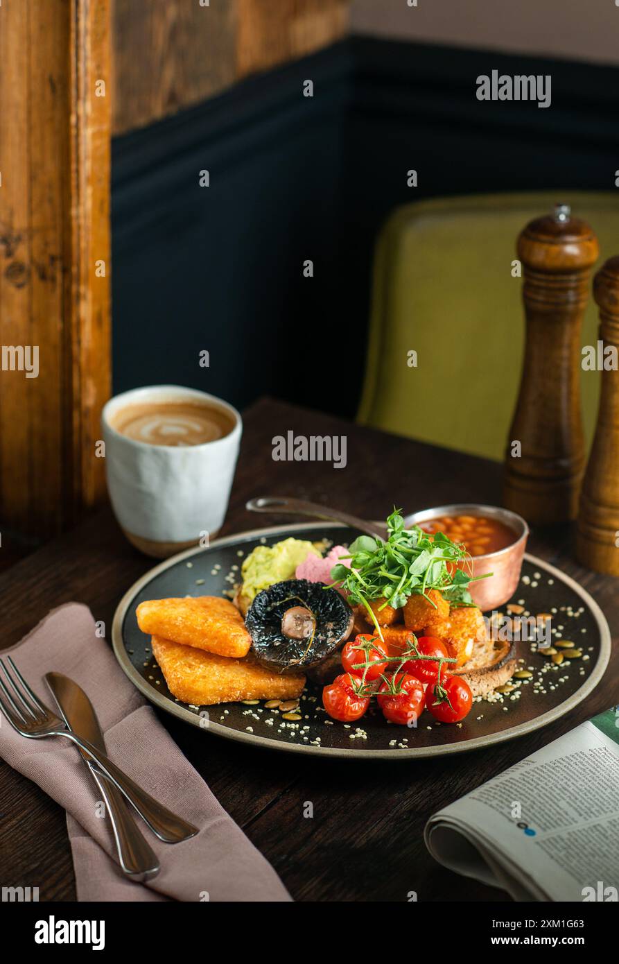 English Breakfast on a black ceramic plate. Wooden table. Full English ...